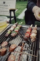 Uma churrasqueira com diversos tipos de carne e legumes assando.