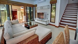 Uma sala de estar moderna com um sofá, TV e uma escada.