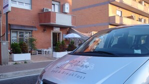Um carro prateado estacionado em frente a um edifício com uma placa que diz 'Le Cause Bed & Breakfast'.