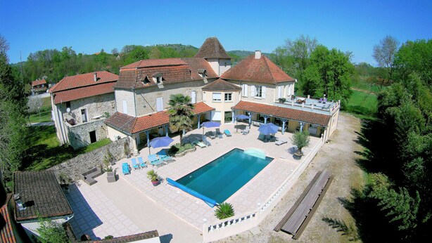 Uma grande villa com piscina, área de estar ao ar livre e jardim.