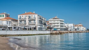 Um hotel à beira-mar com vários andares, varandas e fachada de pedra.