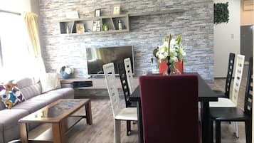 Apartamento família, várias camas, para não fumantes | Sala de estar | TV de tela plana