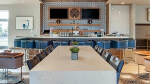 Uma cozinha moderna com ilha central, espaço para bar e assentos.