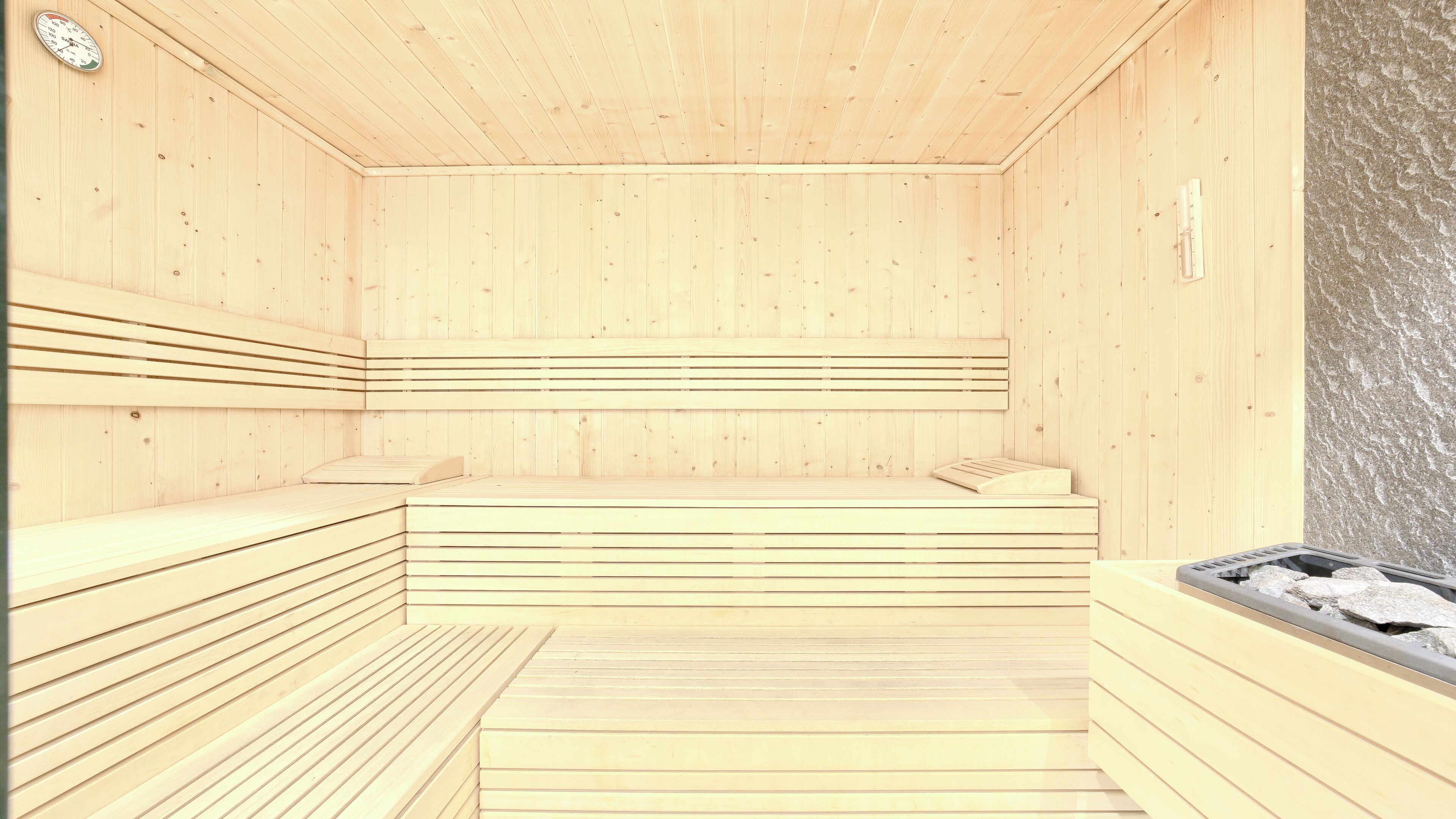 Uma sauna com bancos de madeira e parede de pedra.
