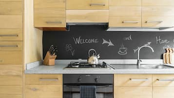 Apartamento, 3 quartos | Cozinha privada | Um frigorífico, um micro-ondas, um forno, uma placa de cozinha