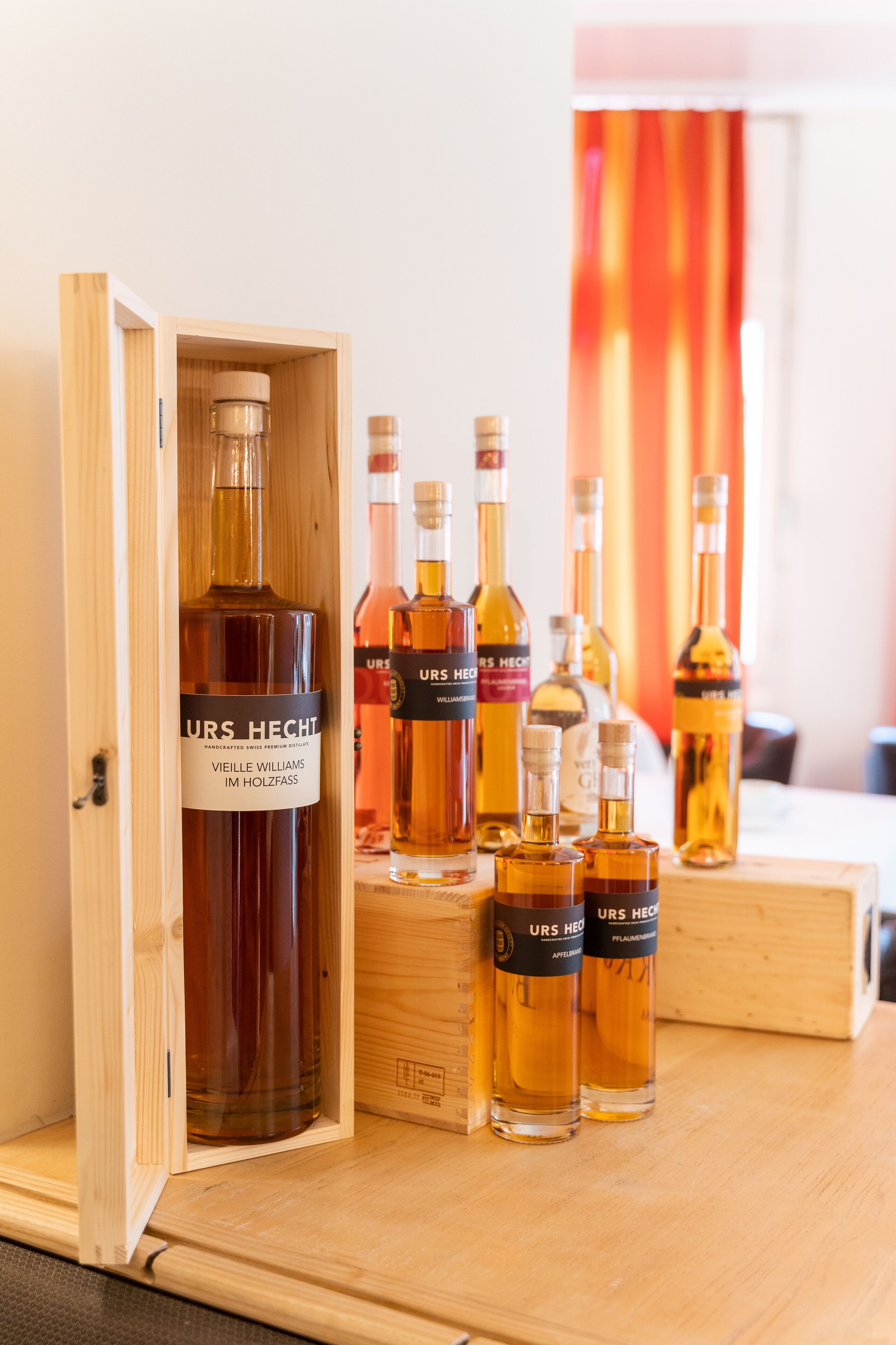 Uma caixa de madeira com garrafas de vinho e destilados 'Urs Hecht'.