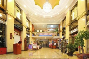 Um hall amplo com teto alto, escadaria central e vários níveis.