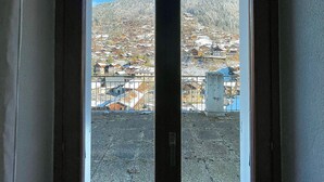 Janela com vista para uma paisagem nevada e edifícios.