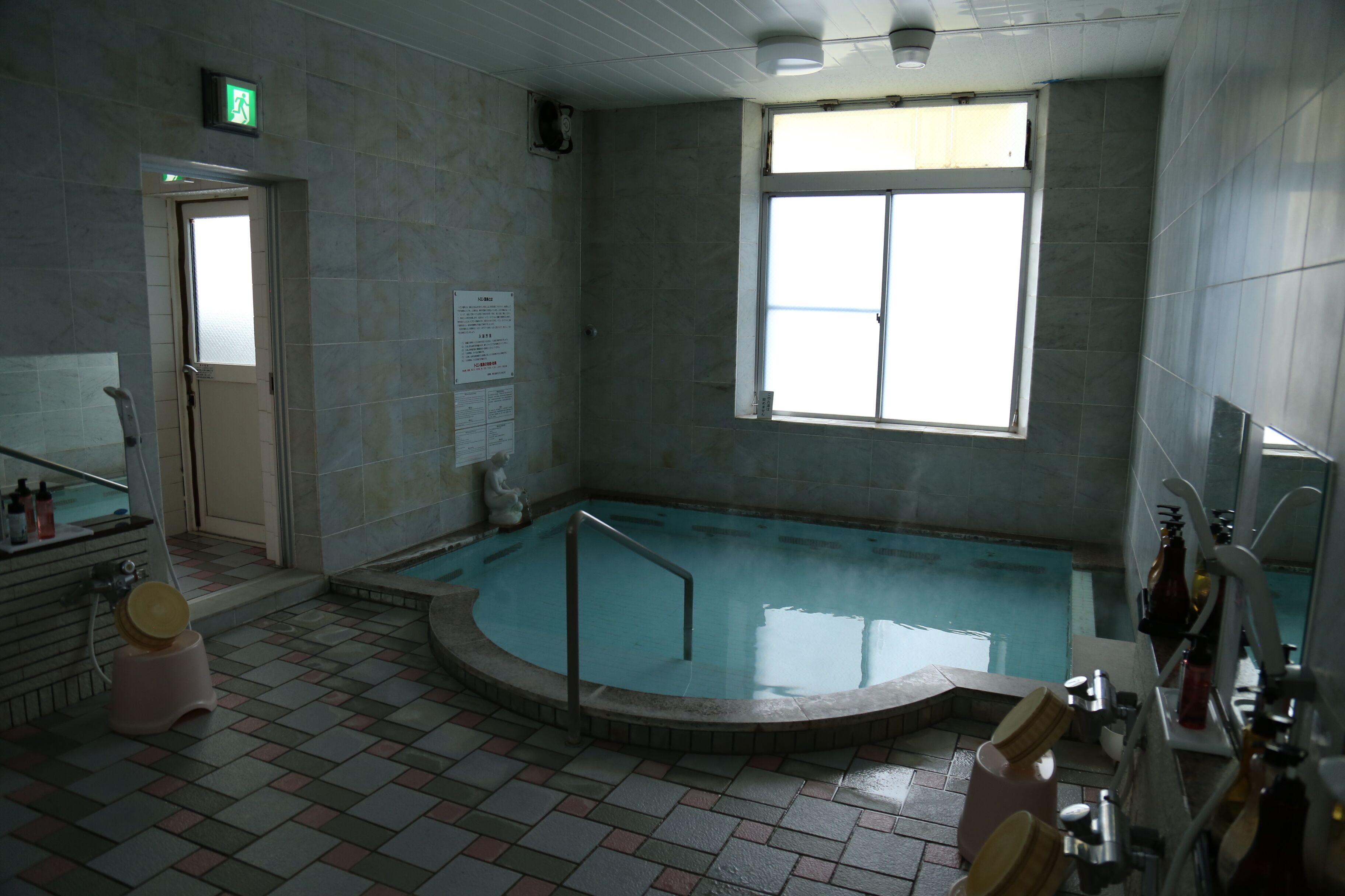 Área de piscina com piso em azulejo, uma janela e uma porta que dá para outro cômodo.