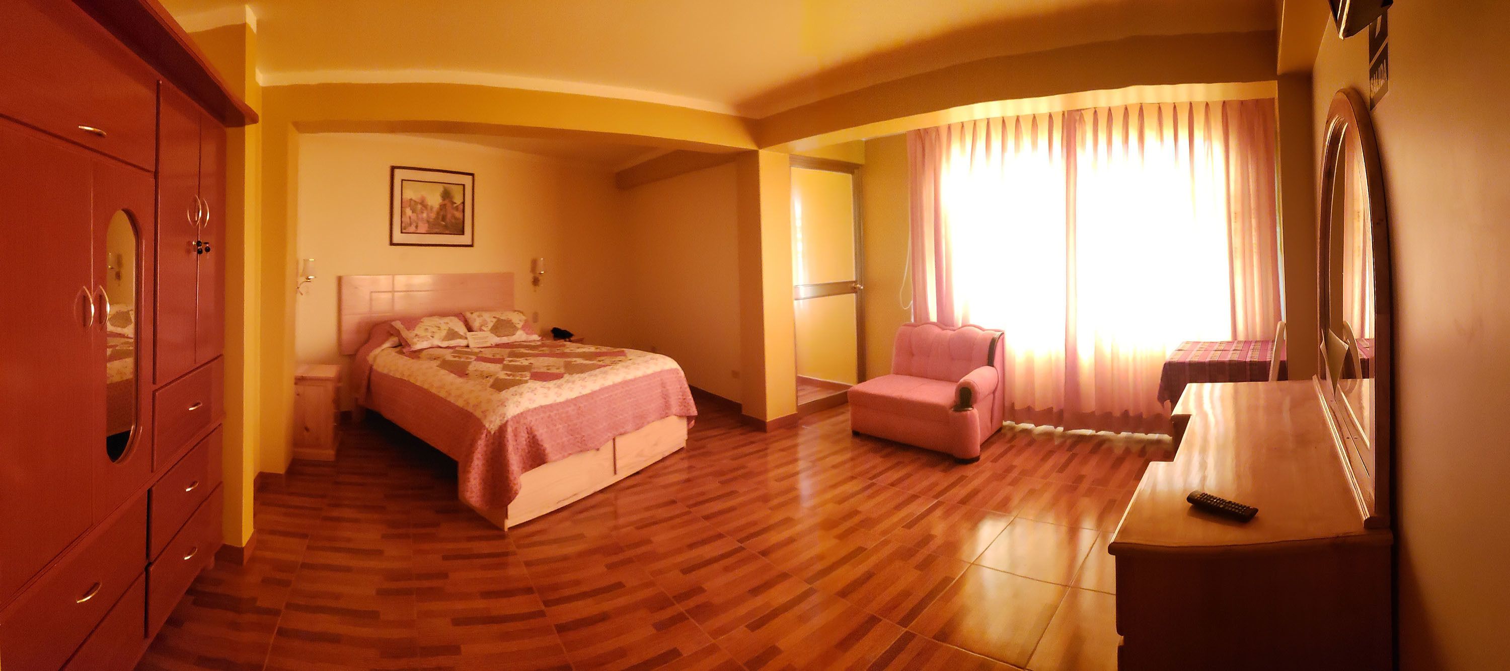 Quarto com cama, cadeira, cômoda e espelho.