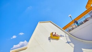Um tobogã com céu azul claro e guarda-corpo lateral.