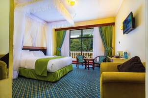 Quarto de hotel com cama, varanda, mesa e cadeira.