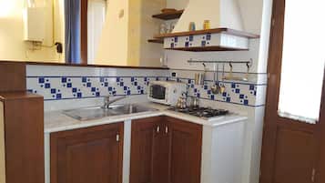 Uma placa de cozinha, uma máquina de café expresso, uma cafeteira/bule
