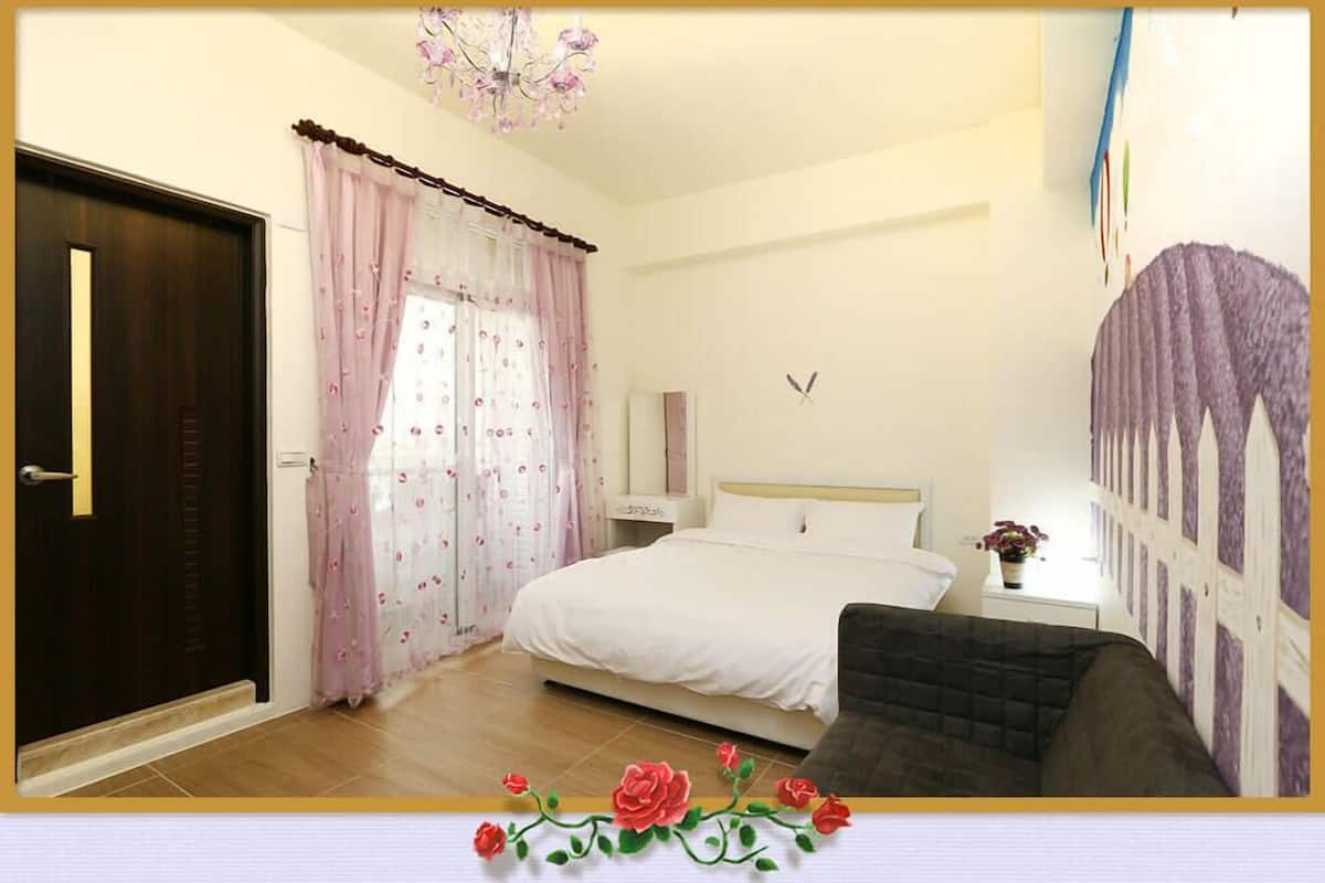 Quarto com cama, mesa de cabeceira, cadeira, porta e parede com detalhe decorativo.