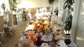 Um buffet de café da manhã com diversas opções de comida e acompanhamentos.