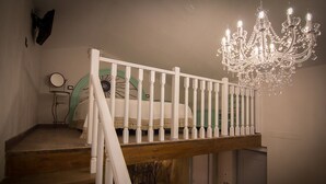 Quarto com uma cama beliche, um candelabro e um pequeno espelho redondo.