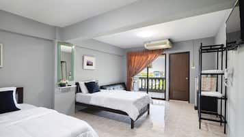 Quarto de hotel com duas camas, varanda e televisão.