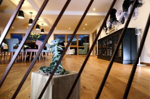 Decoração moderna com área de jantar, piso de madeira e vista pela janela.
