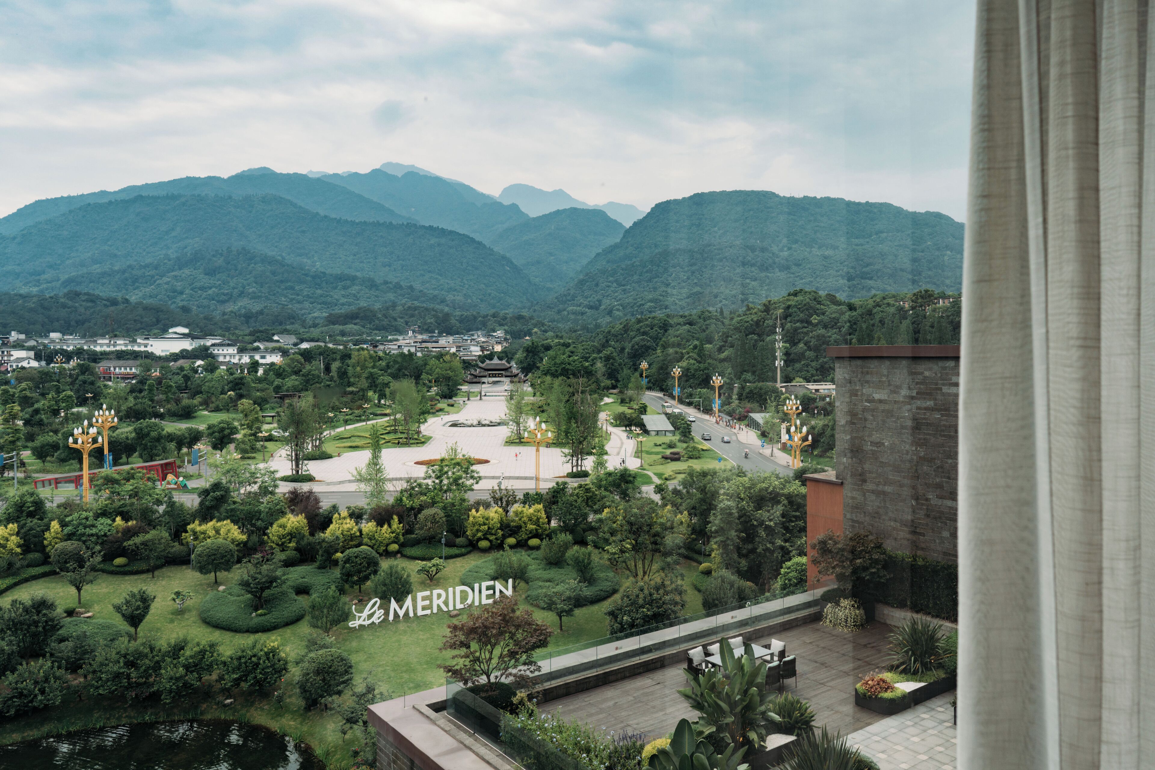 Vista de uma área ajardinada com uma placa indicando "MERIDIEN" e um corpo d'água.