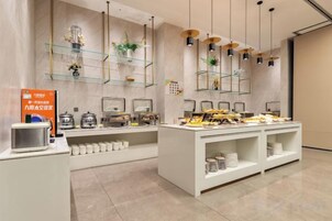 Espaço de café da manhã moderno com prateleiras de vidro, balcão de buffet e luminárias pendentes.