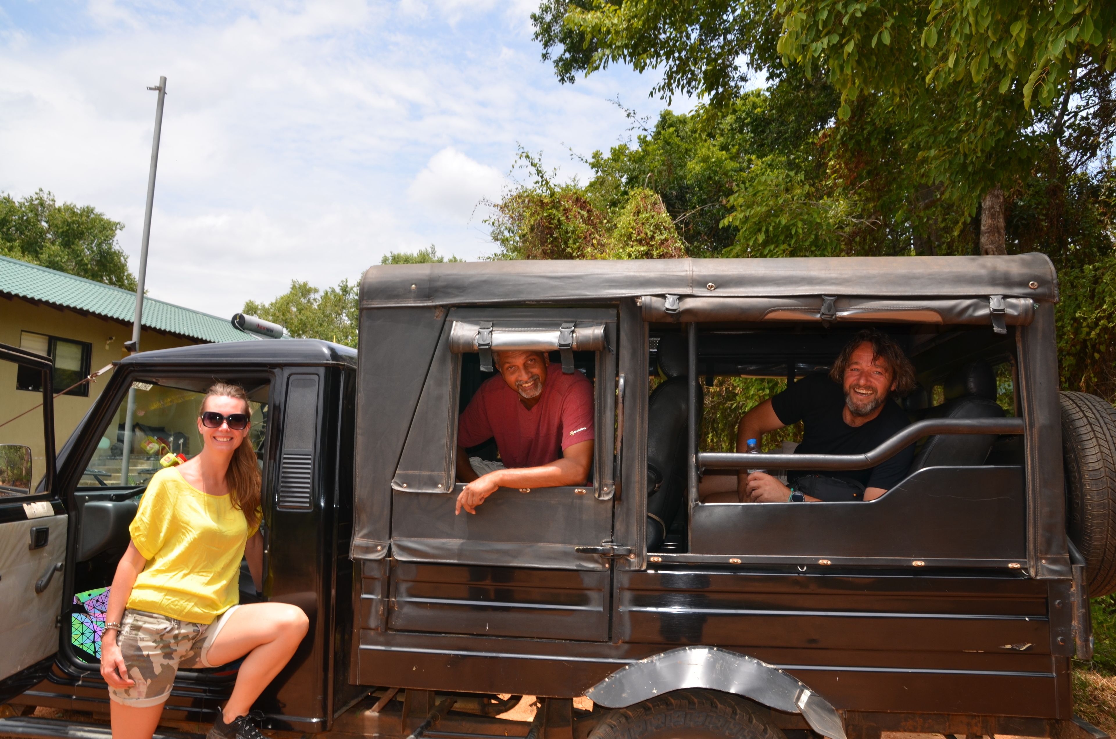 Um veículo com duas pessoas, uma delas debruçada na janela.