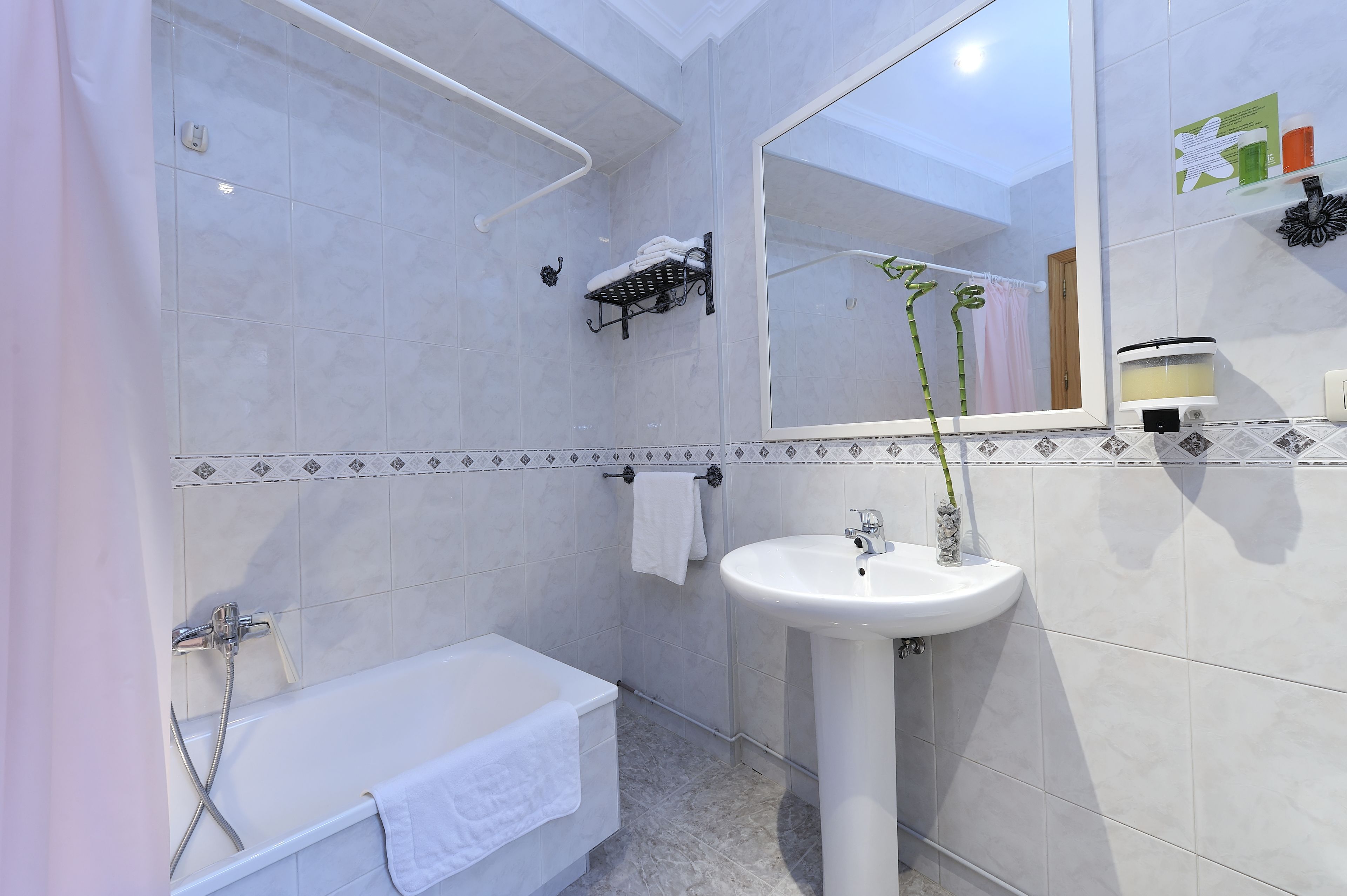 Uma casa de banho moderna com banheira, lavatório e espelho.