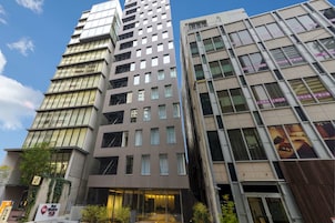 Um edifício moderno de arranha-céu com vários andares, grandes janelas e fachada de vidro.