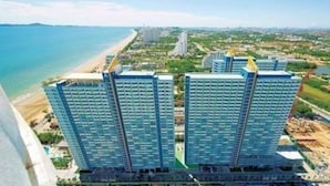 Um edifício alto com design moderno, situado perto de uma praia.
