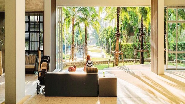 Um hall espaçoso com uma grande janela que oferece vista para um jardim tropical.