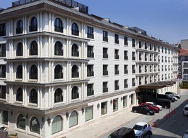 Um hotel com vários andares e design arquitetônico clássico, com janelas em arco e varandas.