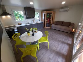 Uma cozinha moderna com área de refeições, um sofá e vista para o exterior.