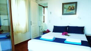 Quarto de hotel com cama, banheiro e porta.