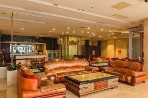 Um hall com sofás de couro, uma mesa de centro e um espaço bar.
