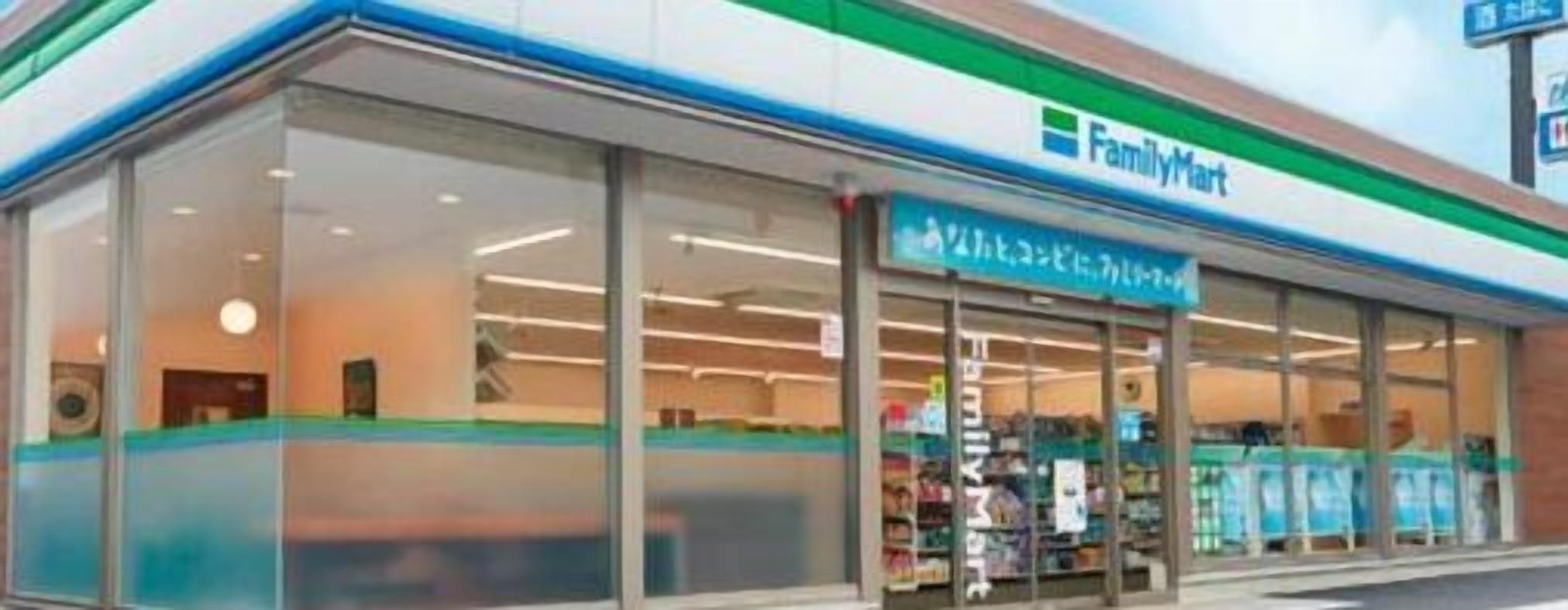 Uma loja FamilyMart com grandes janelas de vidro e fachada verde e branca.