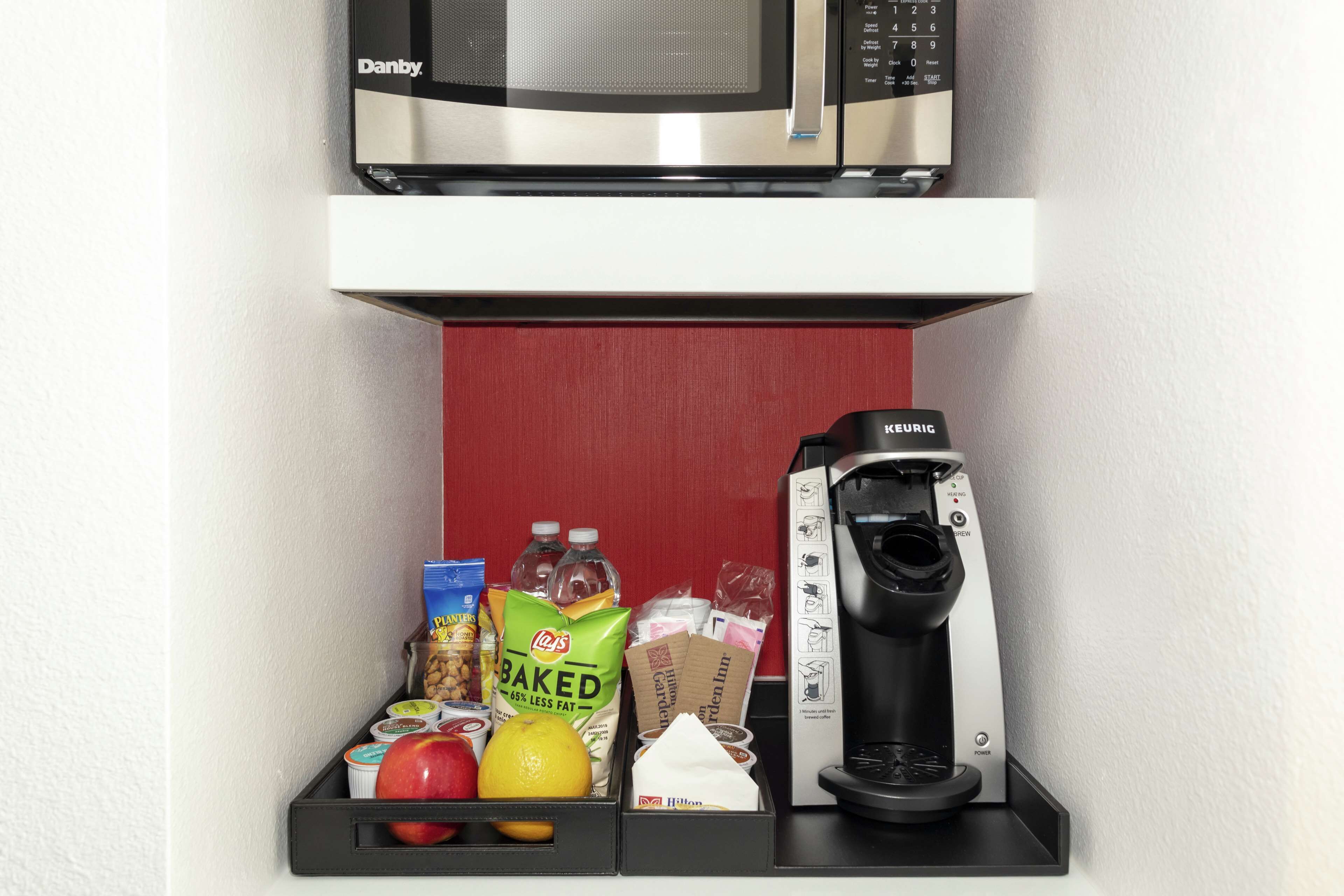 Copa com micro-ondas, cafeteira Keurig e diversos alimentos.