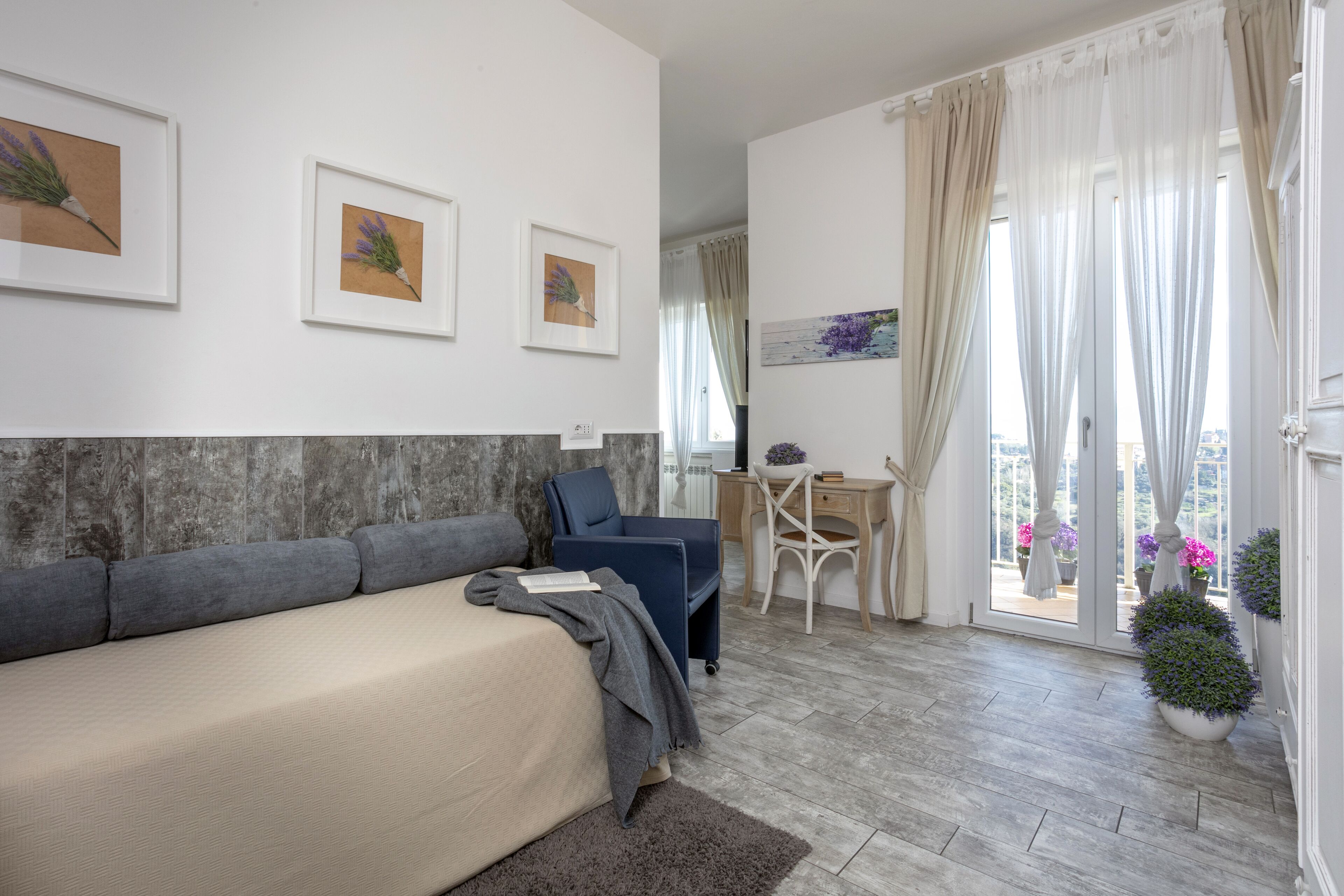 Quarto moderno com sofá, escrivaninha e vista para o exterior.