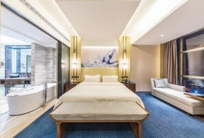 Quarto de hotel moderno com uma cama grande, um sofá, uma escrivaninha e um banheiro com banheira.