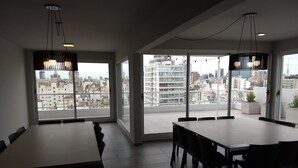 Ampla área de refeições com grandes janelas e vista para a cidade.