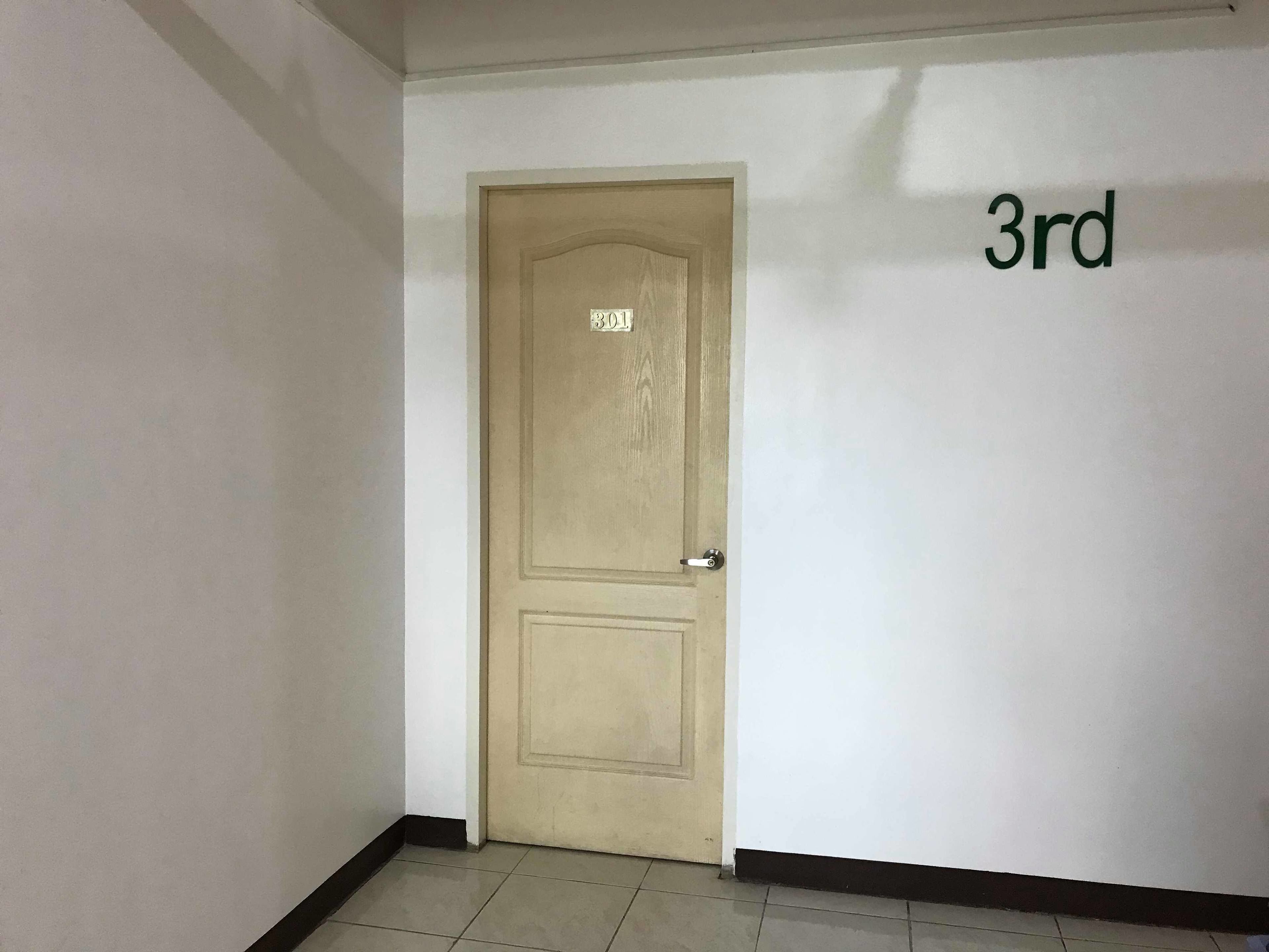 Corredor com uma porta identificada com o número '301' e uma placa na parede indicando '3º'.