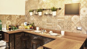 Uma cozinha com painel decorativo atrás do fogão, espaço para café e banquetas.