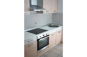 Uma cozinha moderna com forno embutido, fogão e pia.
