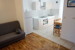 Um espaço compacto com cozinha compacta, sofá e área de refeições.