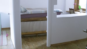 Um quarto com uma cama, uma janela com vista e um quadro na parede.