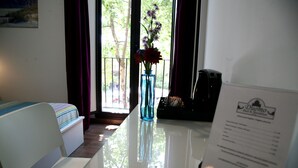 Quarto de hotel com uma cama, um vaso de flores e um menu sobre a mesa.