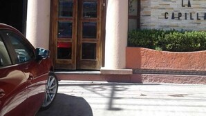 Um edifício com fachada de pedra, um letreiro com a inscrição 