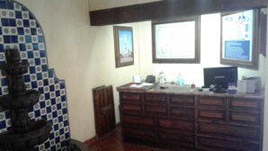 Cozinha com painel de azulejos, uma fonte de pedra, armários de madeira e uma janela com vista.