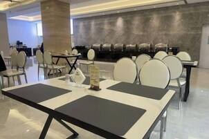 Espaço de refeições de hotel com mesas, cadeiras, balcão e menu, e design de interiores moderno.