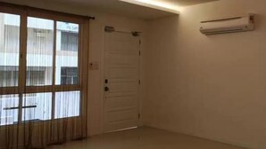 Quarto com uma grande janela, porta e ar condicionado na parede.