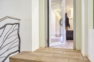 Um interior moderno com uma escada que dá para um corredor.