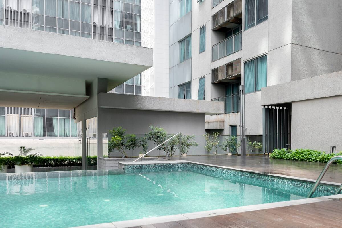 Piscina interna moderna com vista clara da arquitetura e varandas do edifício ao redor.